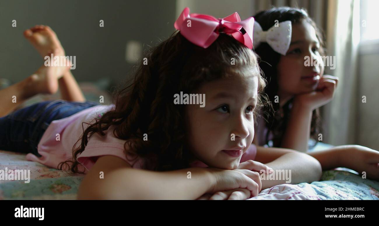 Children lied in bed watching television screen. kid looking at media ...