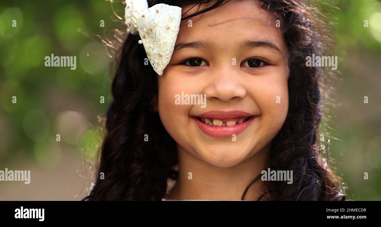 Hispanic child girl smiling portrait face close-up adjusting hair Stock ...