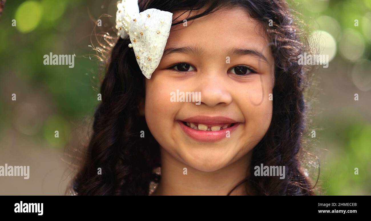 Hispanic child girl smiling portrait face close-up adjusting hair Stock ...