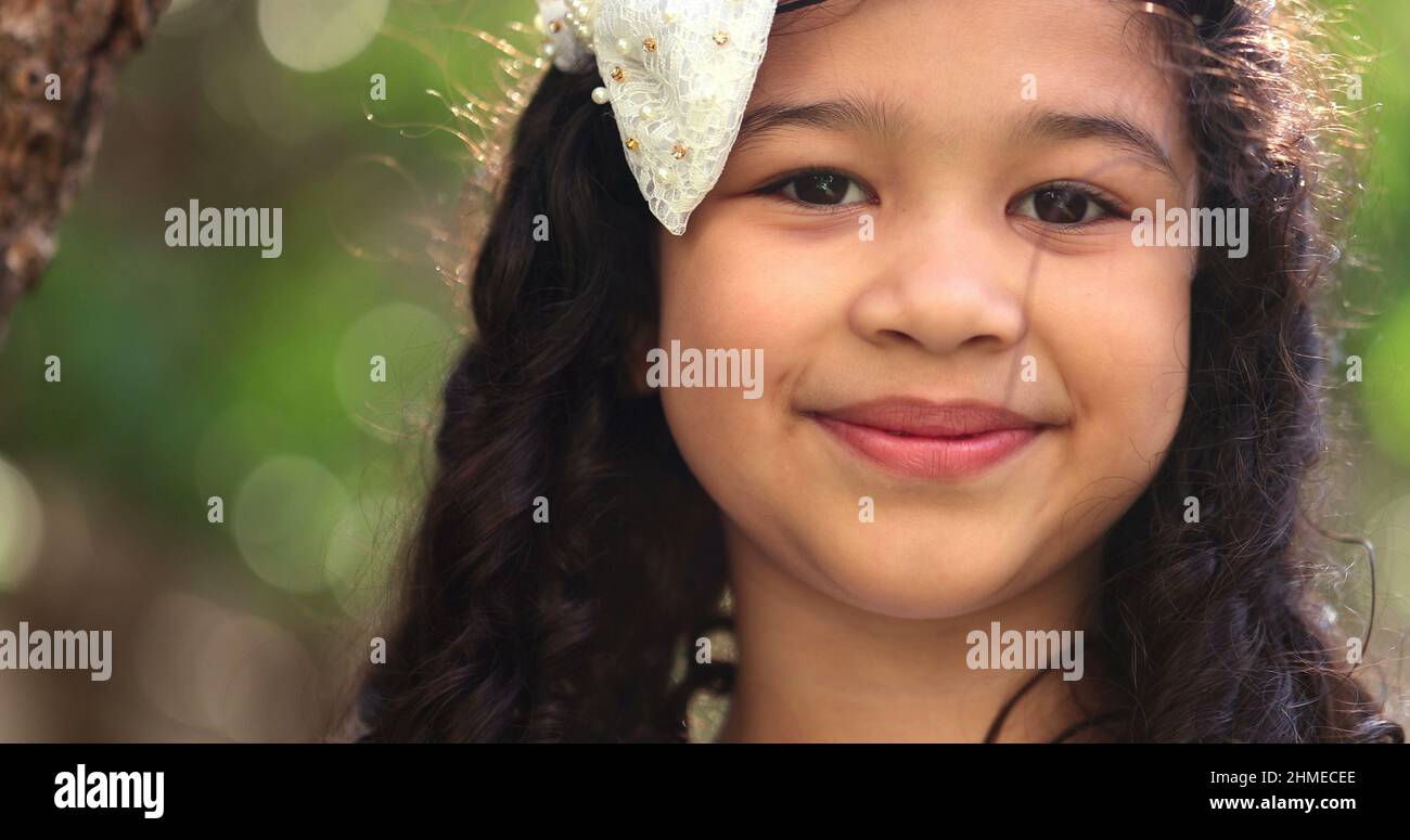 Hispanic child girl smiling portrait face close-up adjusting hair Stock ...