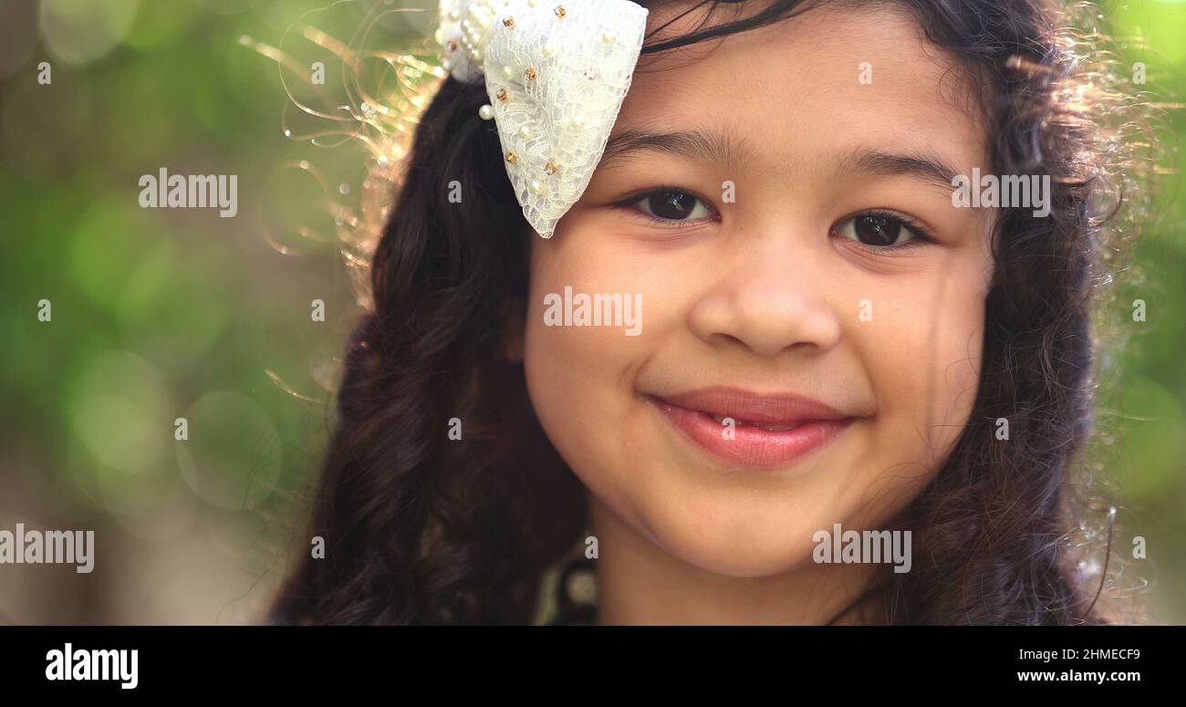 Hispanic child girl smiling portrait face close-up adjusting hair Stock ...