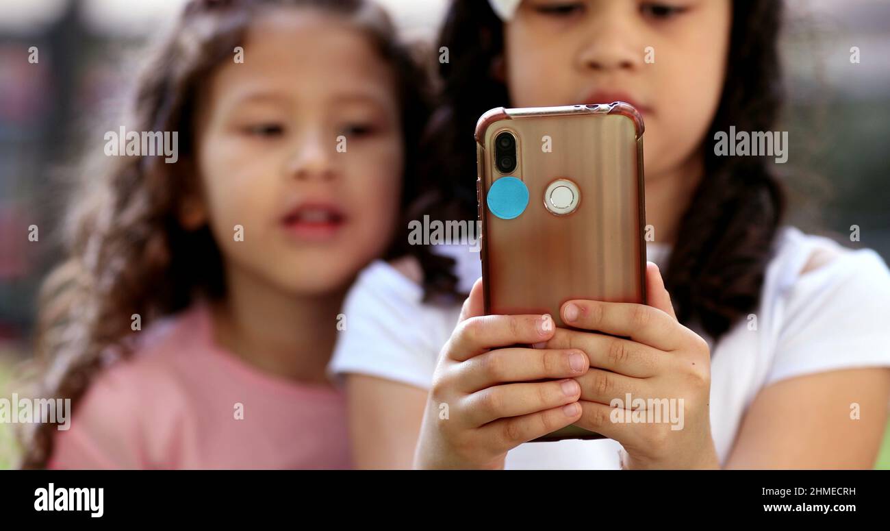 Little girls staring at cellphone screen. children on social media ...