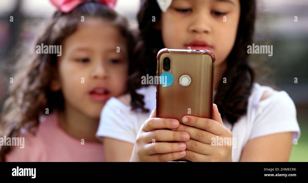 Little girls staring at cellphone screen. children on social media ...