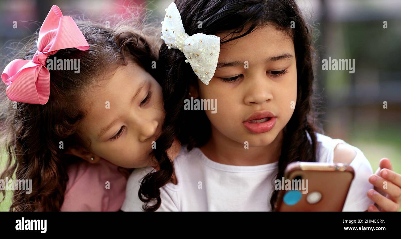 Little girls staring at cellphone screen. children on social media ...