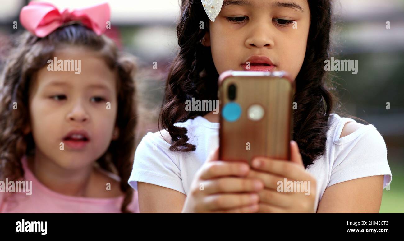 Little girls staring at cellphone screen. children on social media ...