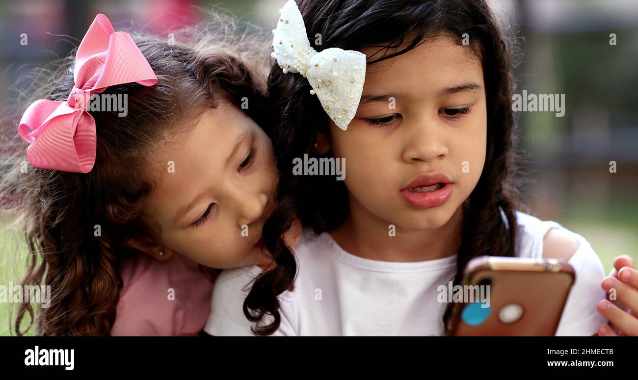 Little girls staring at cellphone screen. children on social media ...