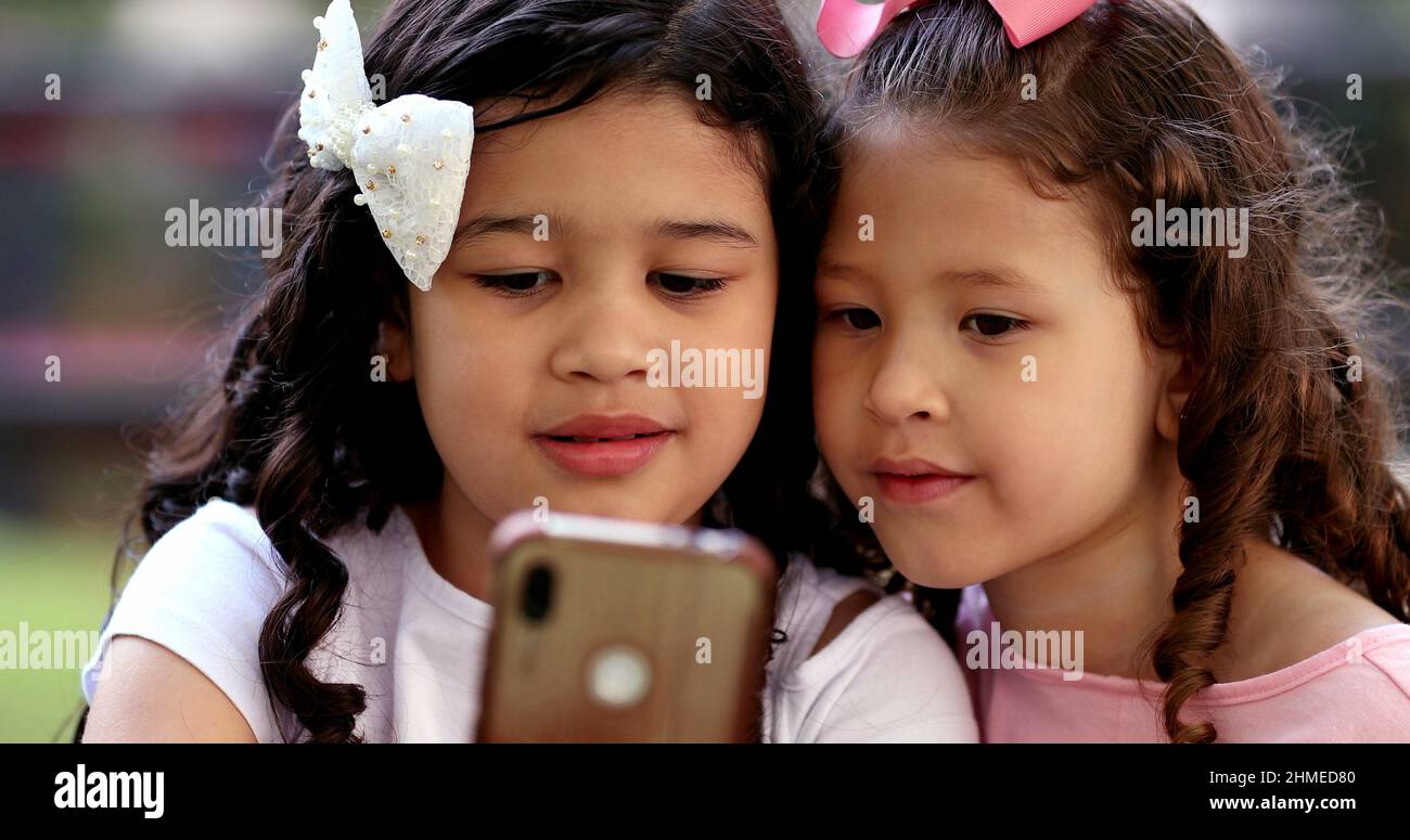 Small little girls staring at cellphone screen Stock Photo - Alamy