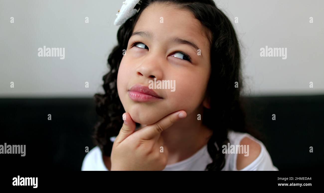 Thoughtful little girl child thinking, pensive kid Stock Photo - Alamy