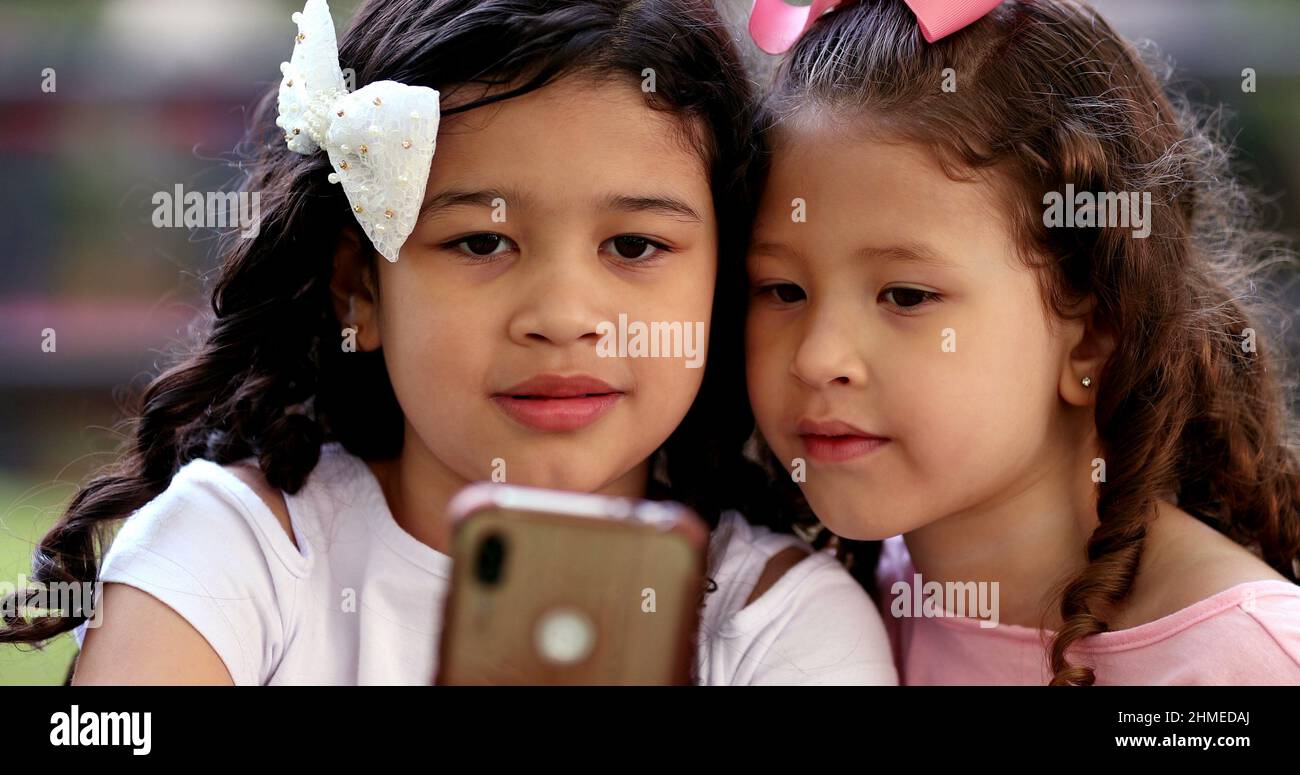 Small little girls staring at cellphone screen Stock Photo - Alamy