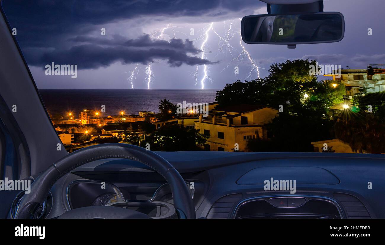 Looking through a car windshield with view of lightning storm over the ...