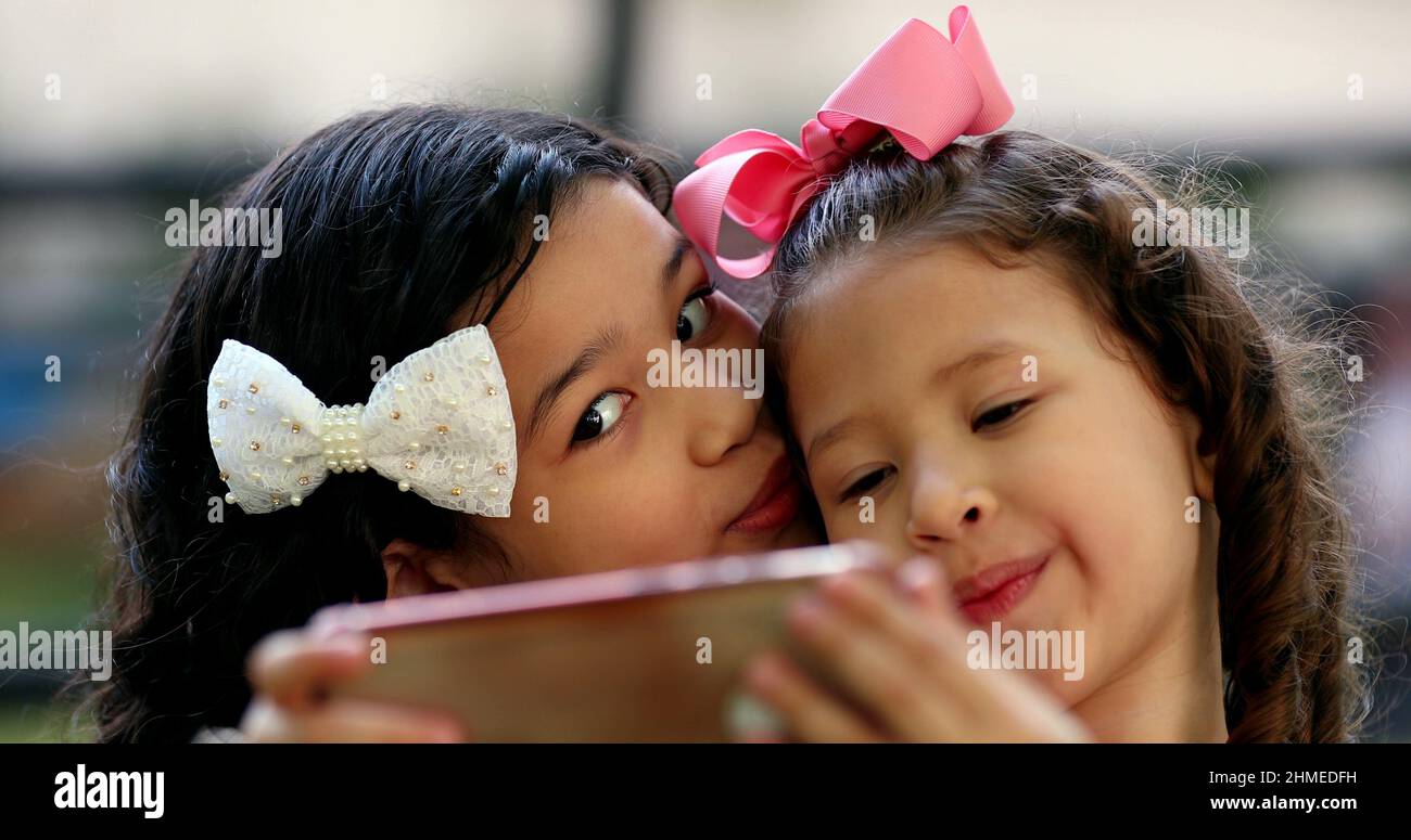 Two little girls posing for selfie with smartphone, children take photo ...