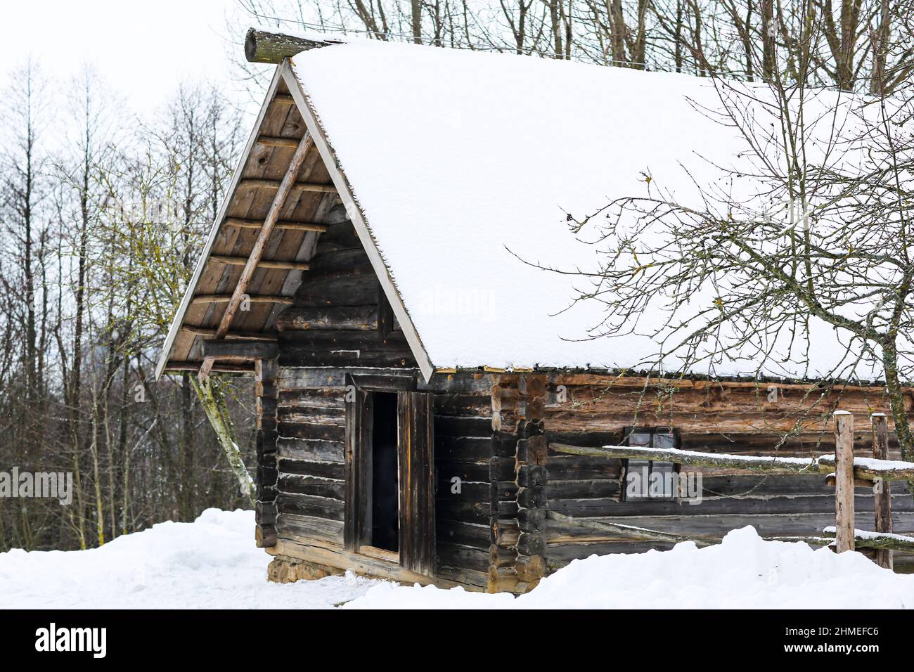 Winter Russian landscape. An old wooden hut, a log house with a ...