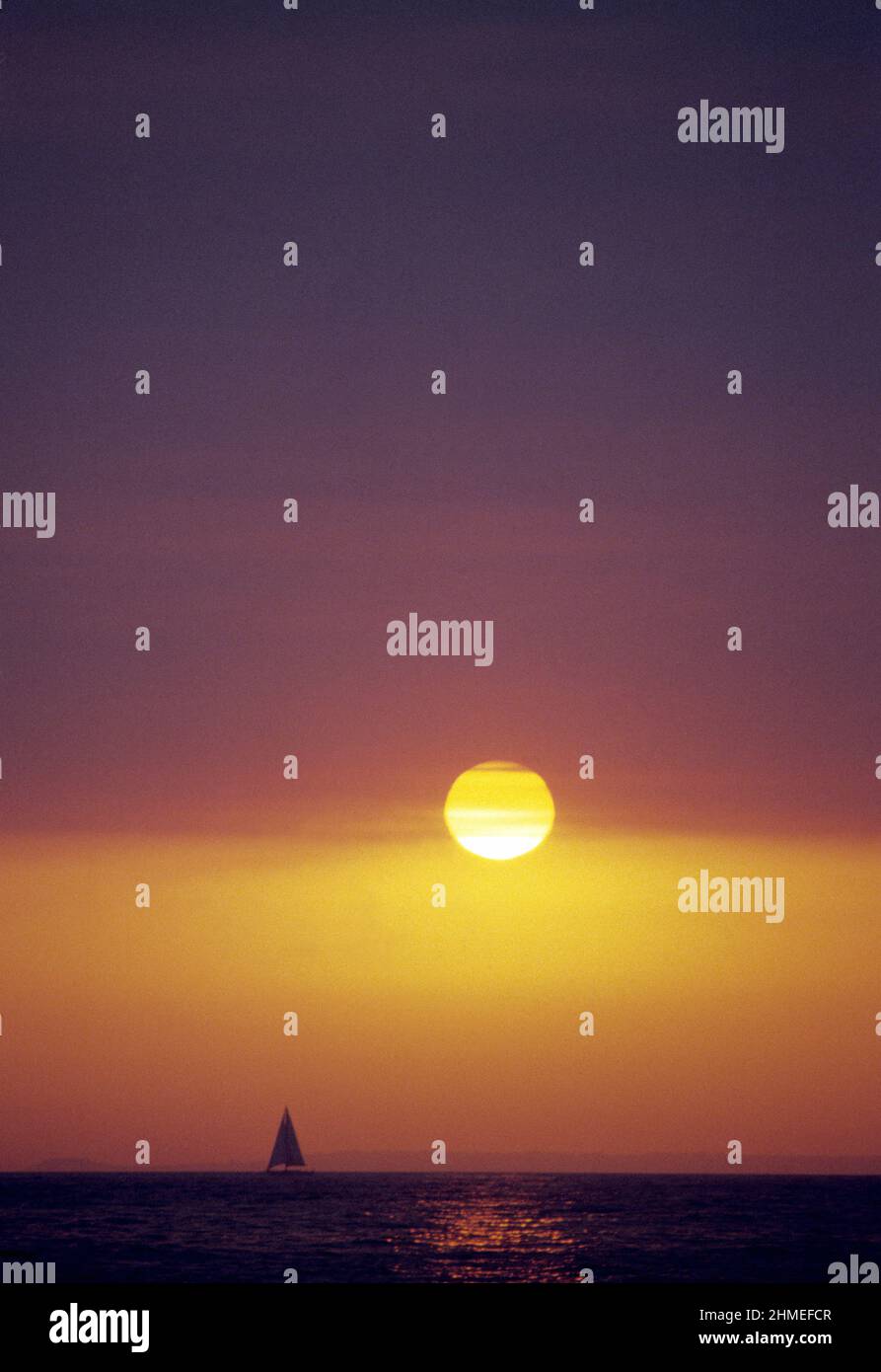 sailing boat far away at sunset Stock Photo - Alamy