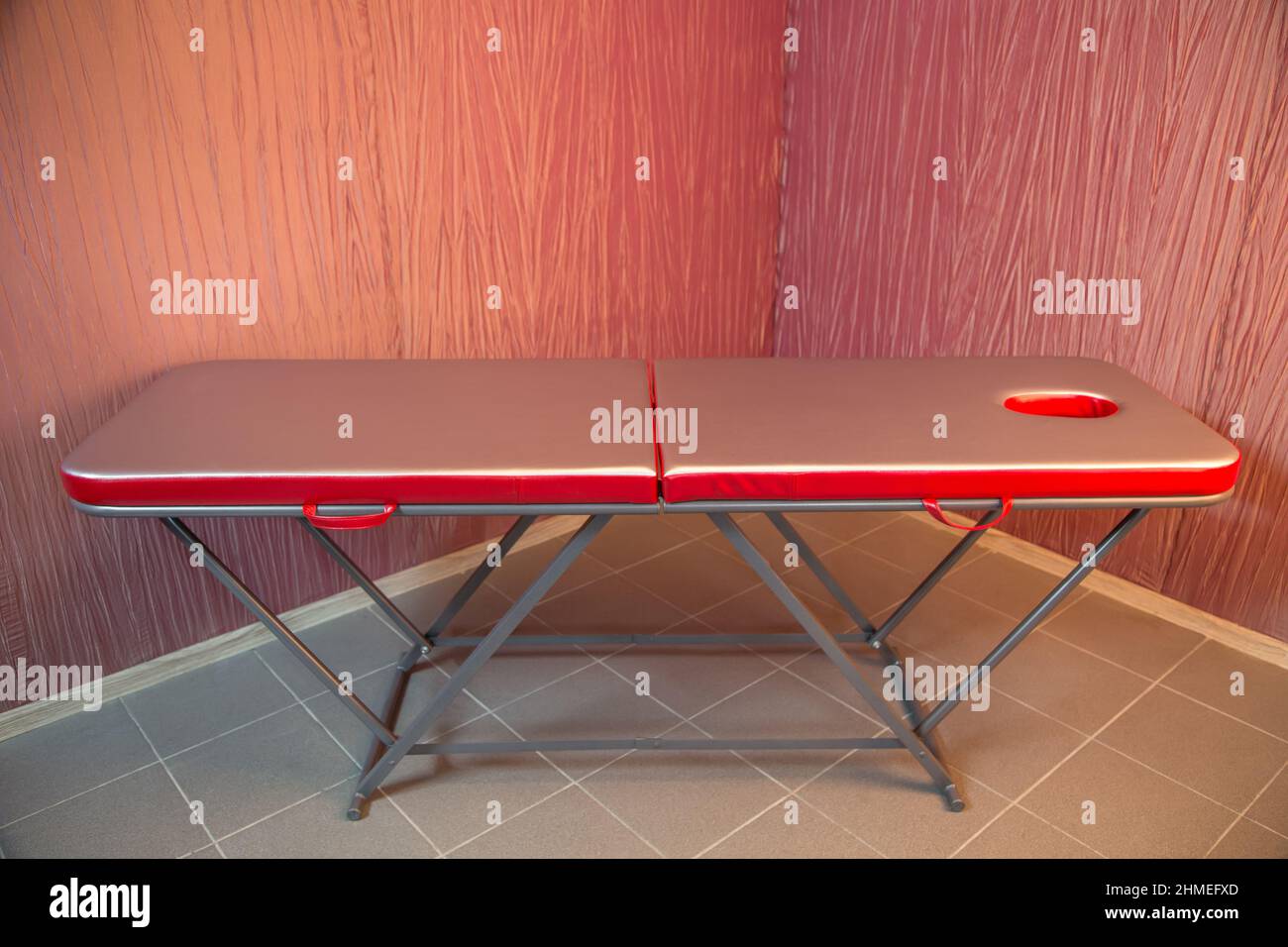 Red relaxation bed for massage standing in the corner of a room with ...