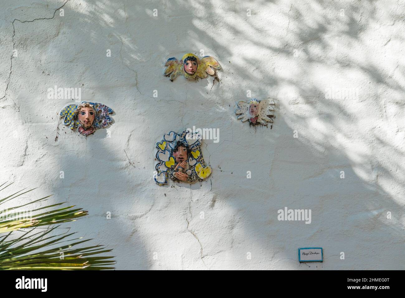 Faces of ceramic people attached to a stucco wall by Santa Barbara ...