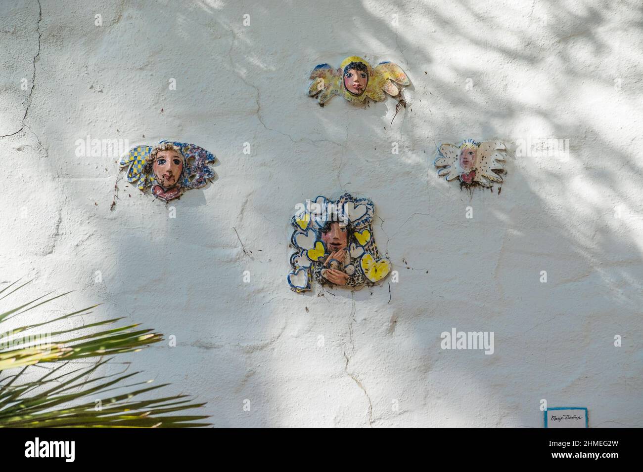 Faces of ceramic people attached to a stucco wall by Santa Barbara ...