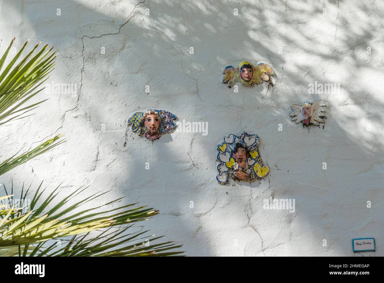 Faces of ceramic people attached to a stucco wall by Santa Barbara ...