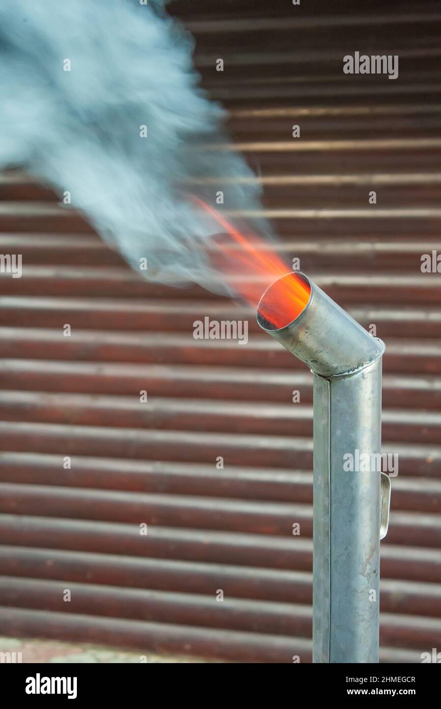 Smoke and fire in the tube on brown background Stock Photo - Alamy