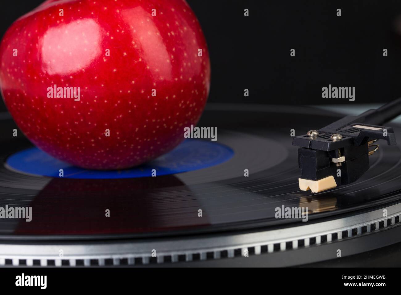 old fashioned turntable playing a track from black vinyl with an apple ...