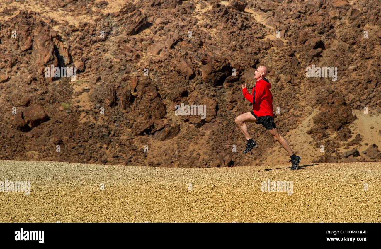 Man running on sand in Tenerife at altitude near volcanoes Stock Photo ...