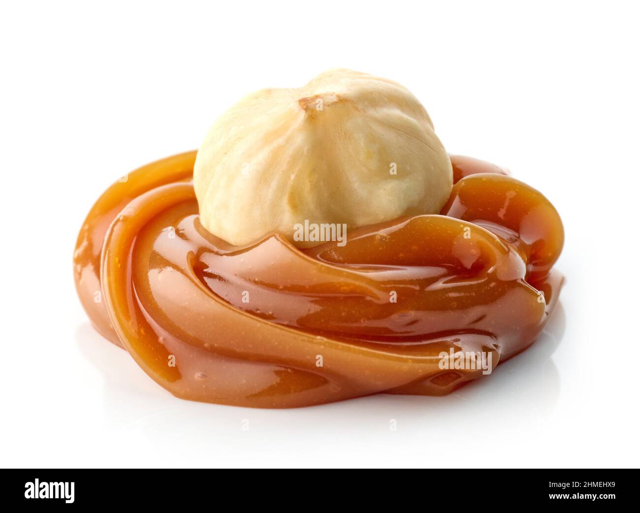 hazelnut in melted caramel macro isolated on white background Stock ...