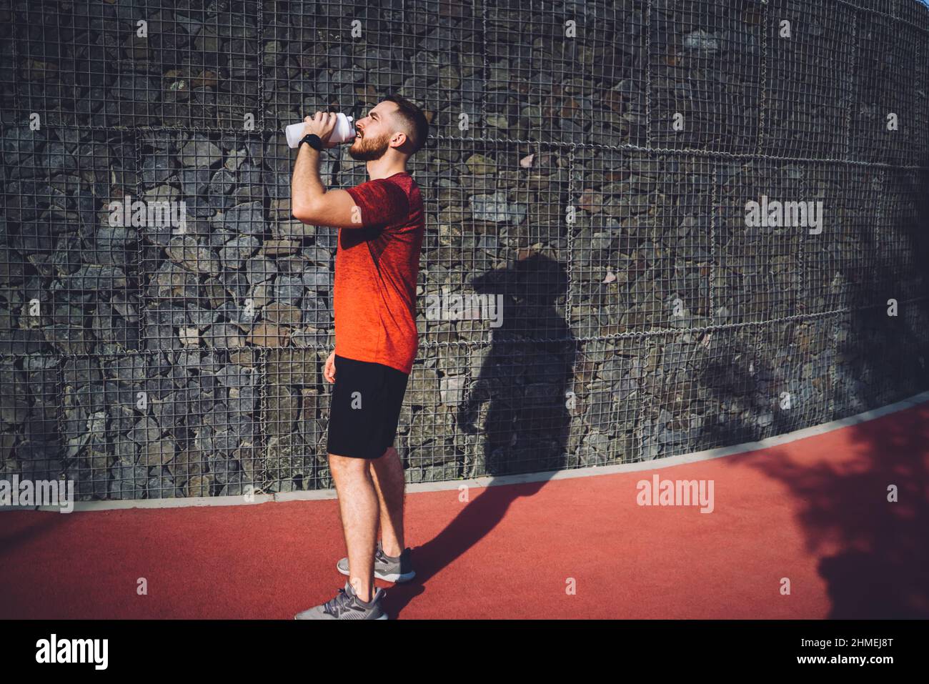 Tired athlete drinking after workout Stock Photo - Alamy