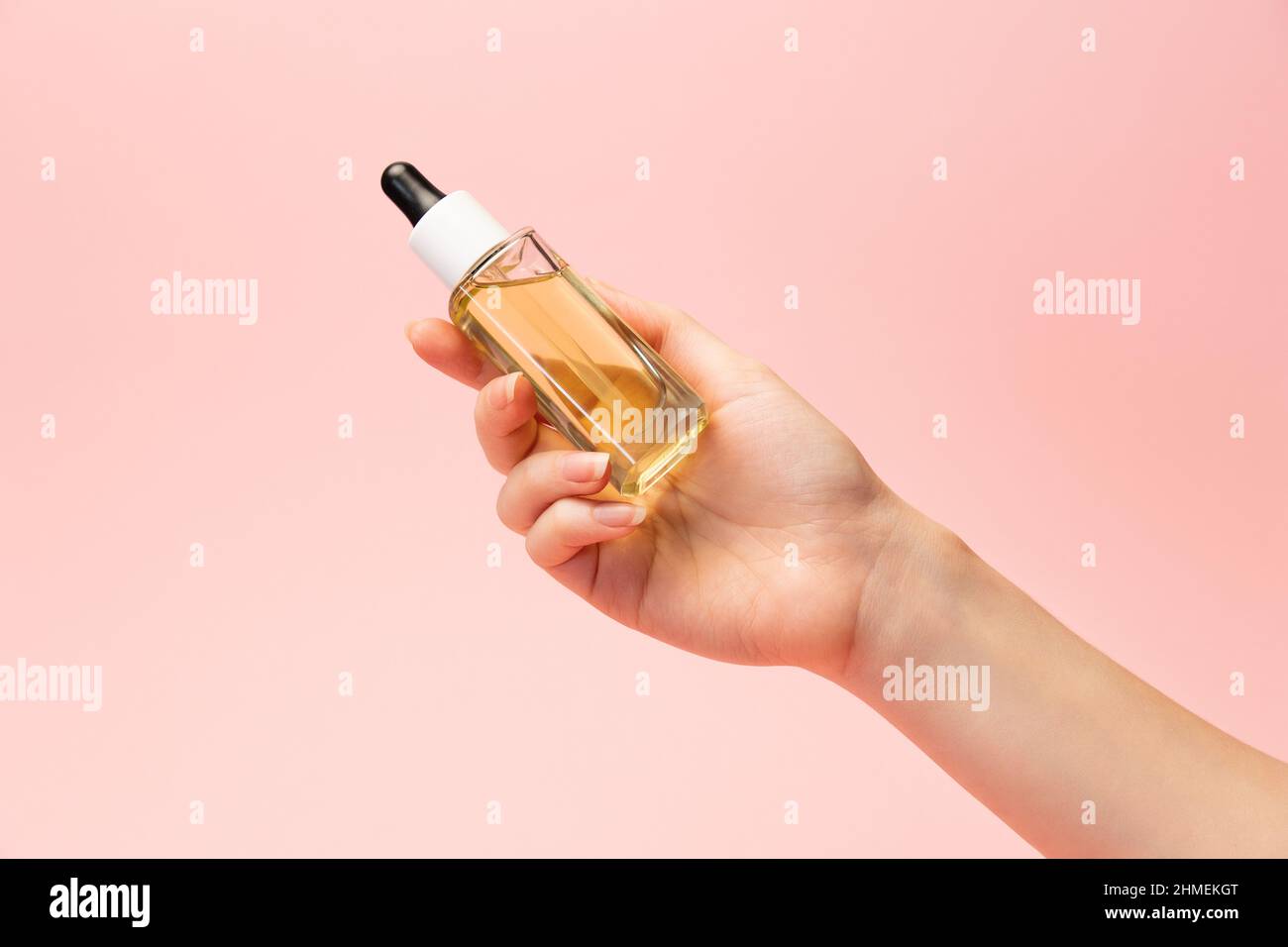 Skin care. Beautiful female hand hold a glass bottle of care cosmetics ...
