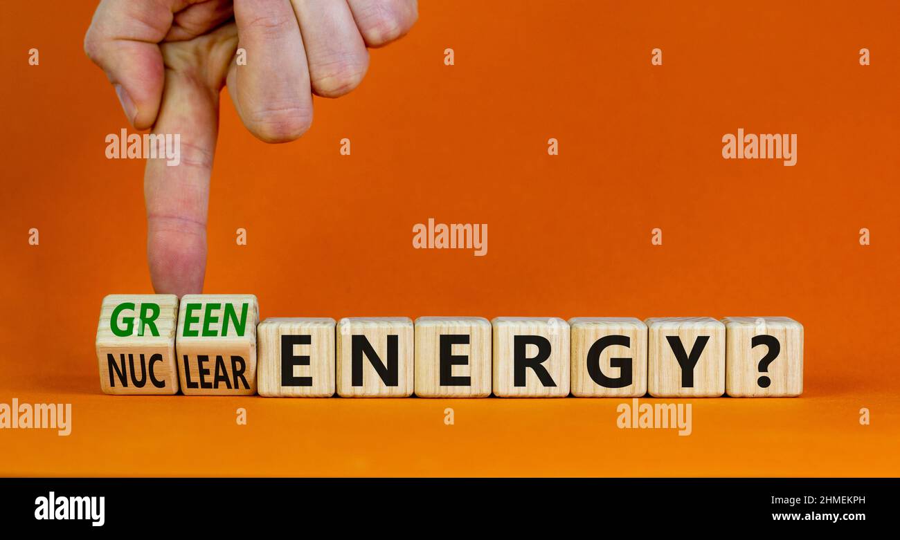 Nuclear or green energy symbol. Businessman turns wooden cubes and ...