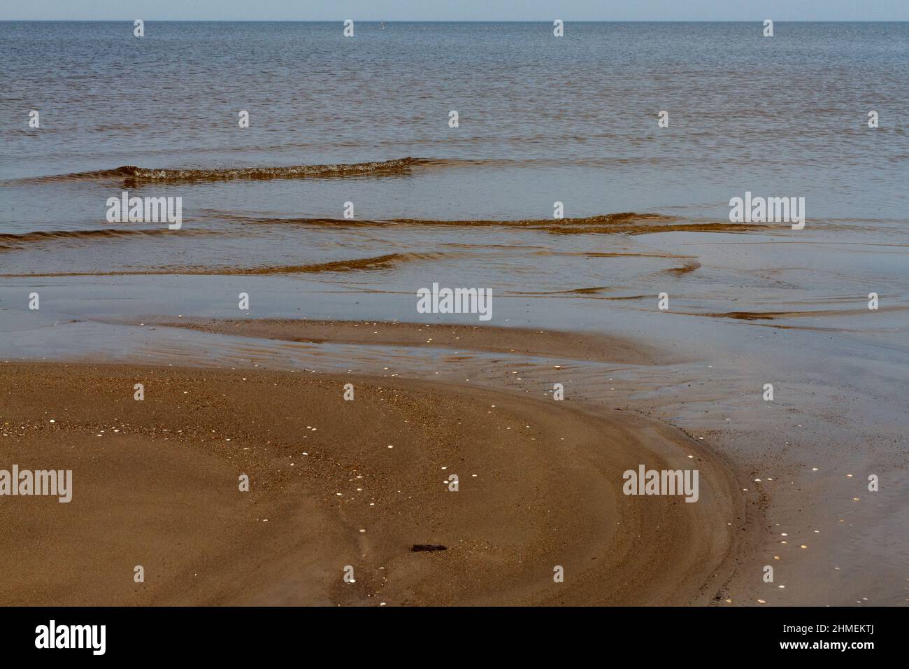 Sandy beach with small sea waves and curvy sand textures Stock Photo ...