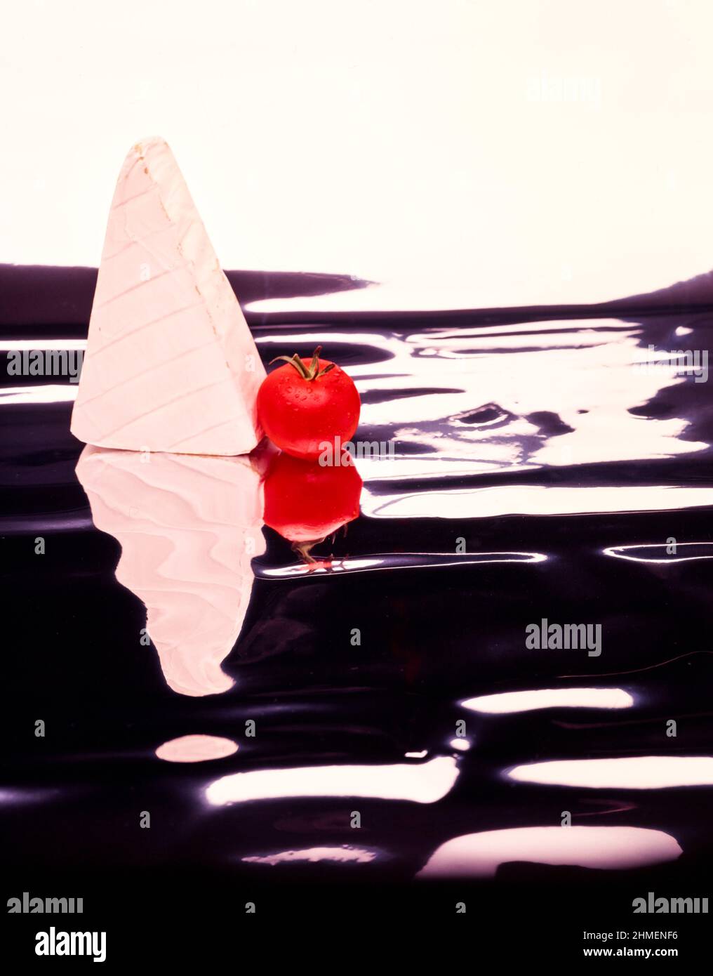 Creative snack food still-life representation of Cheese and Tomato on ...