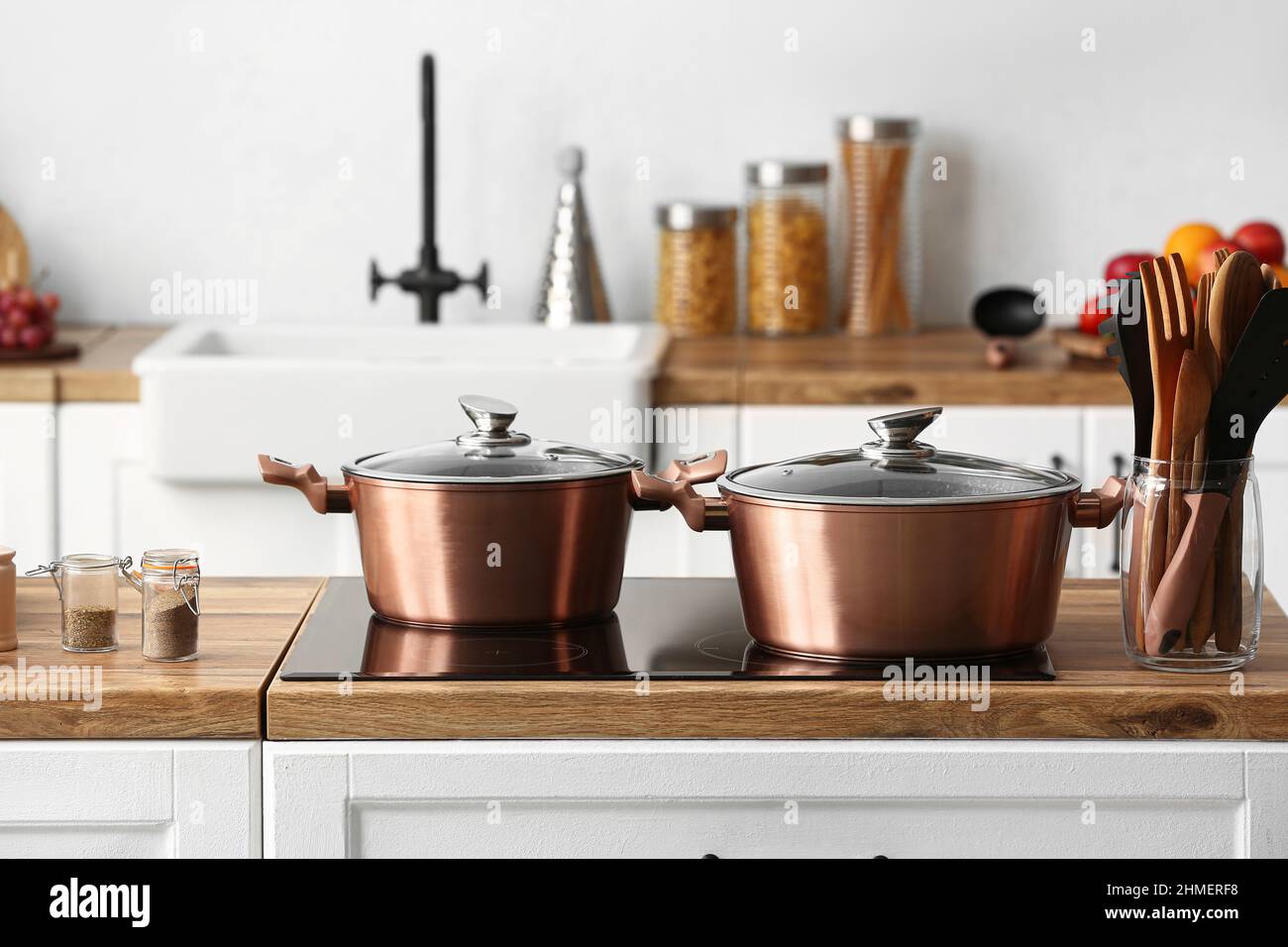 Shiny copper cooking pots on stove in kitchen Stock Photo - Alamy