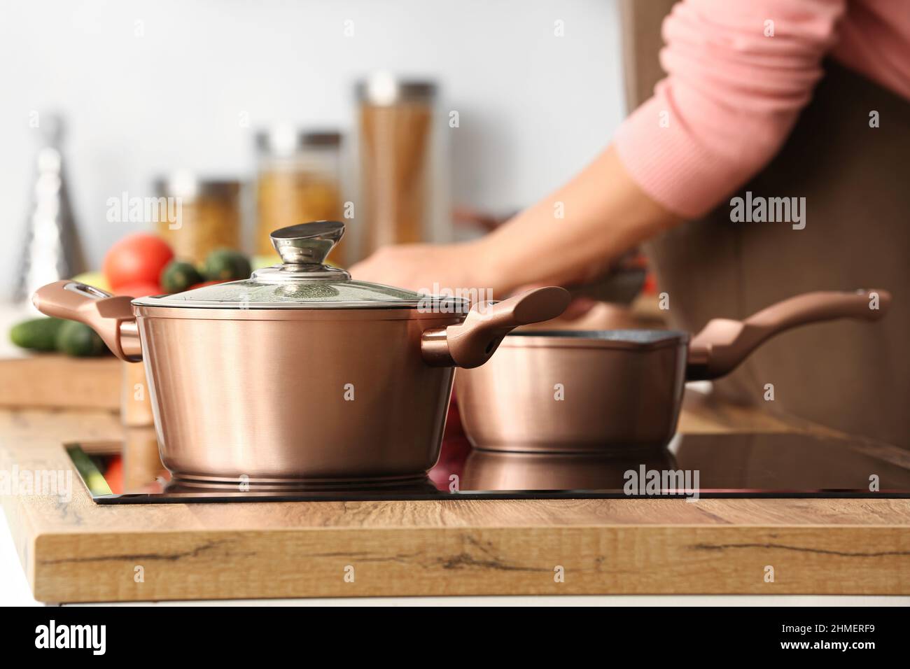Shiny copper cooking pots on stove in kitchen, closeup Stock Photo - Alamy