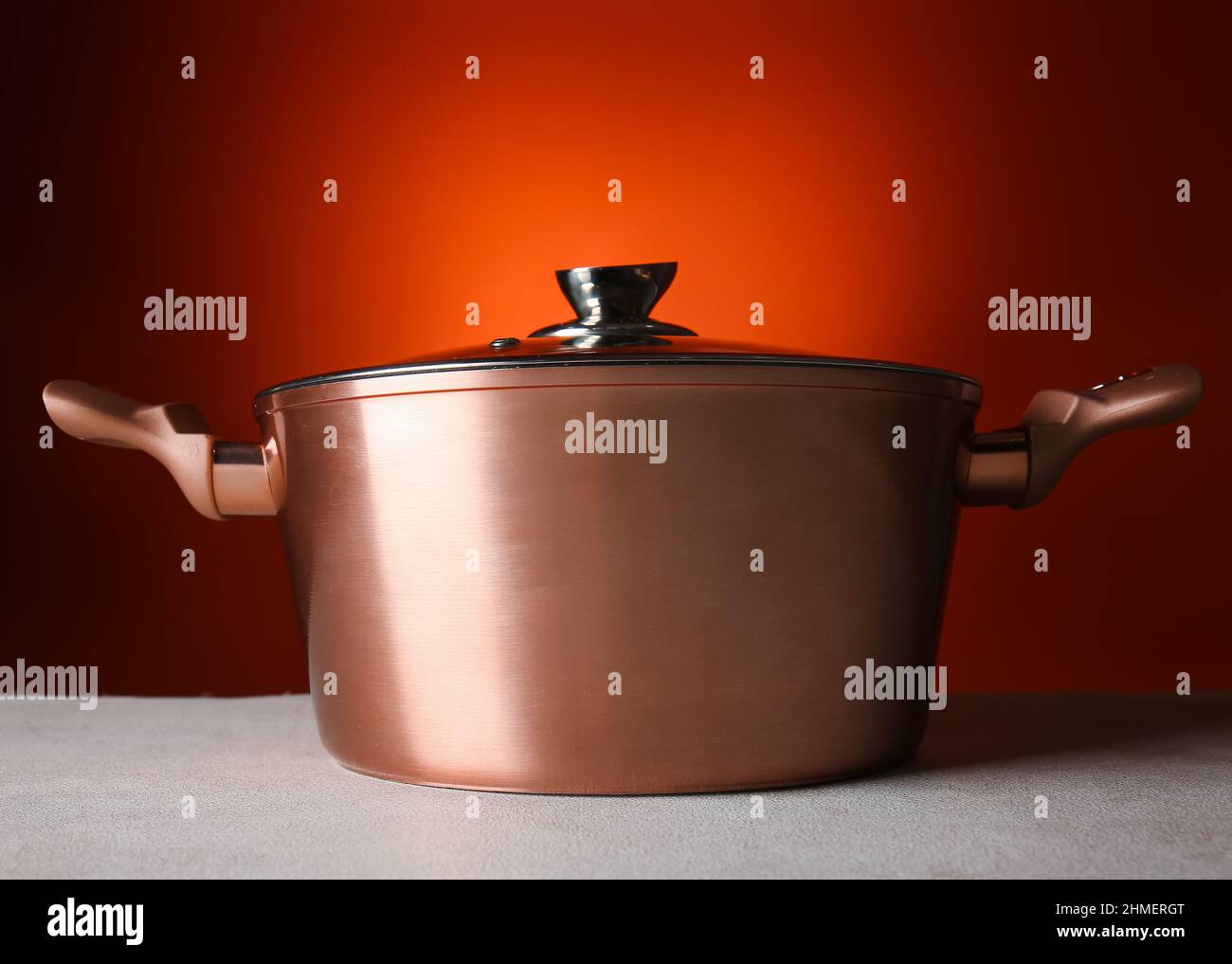Copper cooking pot on table against red background Stock Photo - Alamy