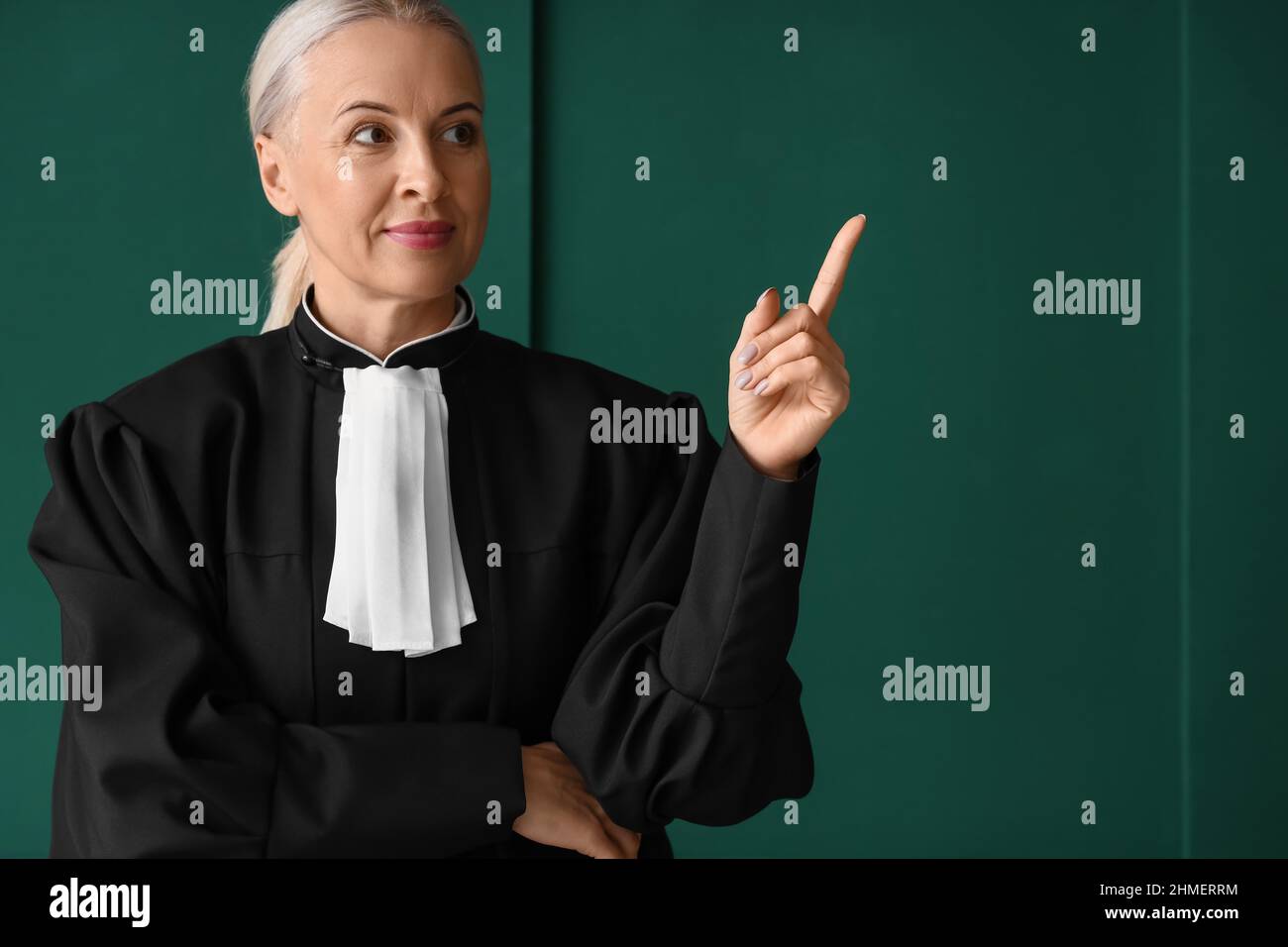 Mature female judge pointing at something on green background Stock ...
