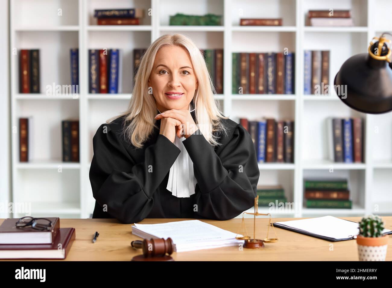 Mature female judge sitting at table in courtroom Stock Photo - Alamy