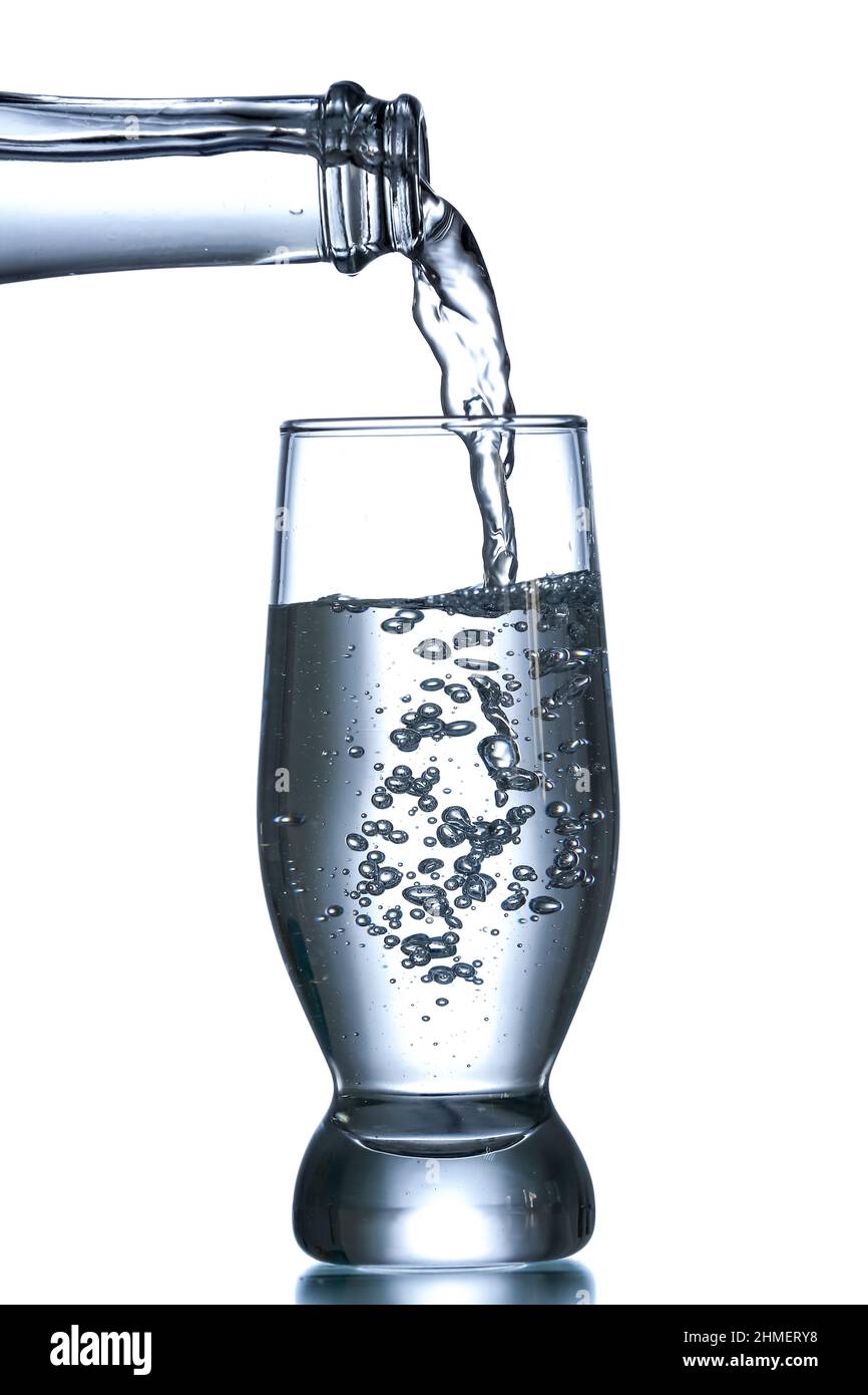 Pouring of clear water in glass isolated on white Stock Photo - Alamy