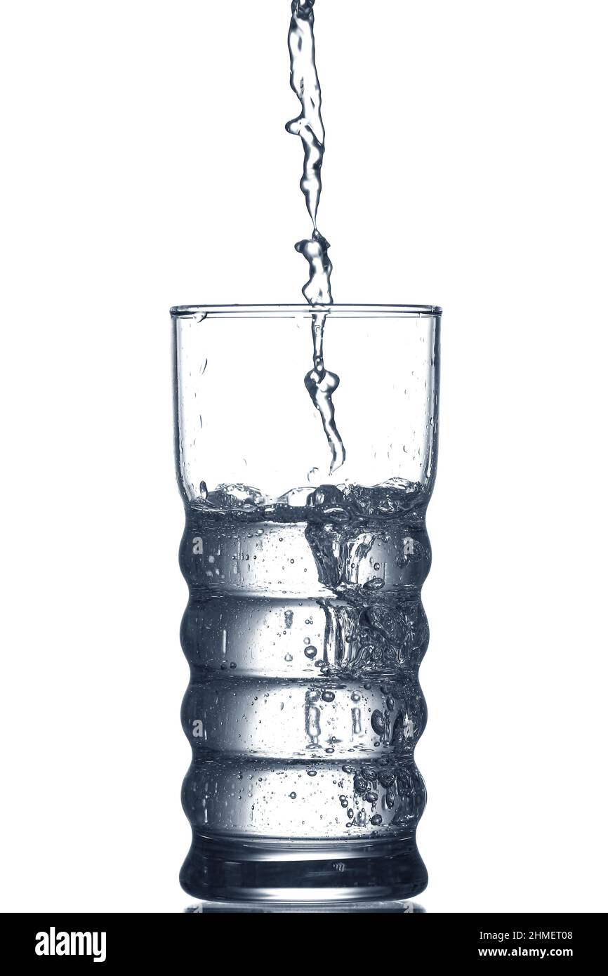 Pouring of clear water in glass isolated on white Stock Photo - Alamy