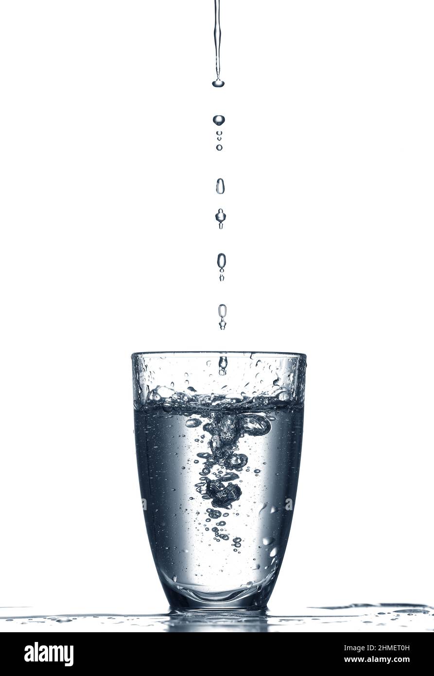 Pouring of clear water in glass isolated on white Stock Photo - Alamy