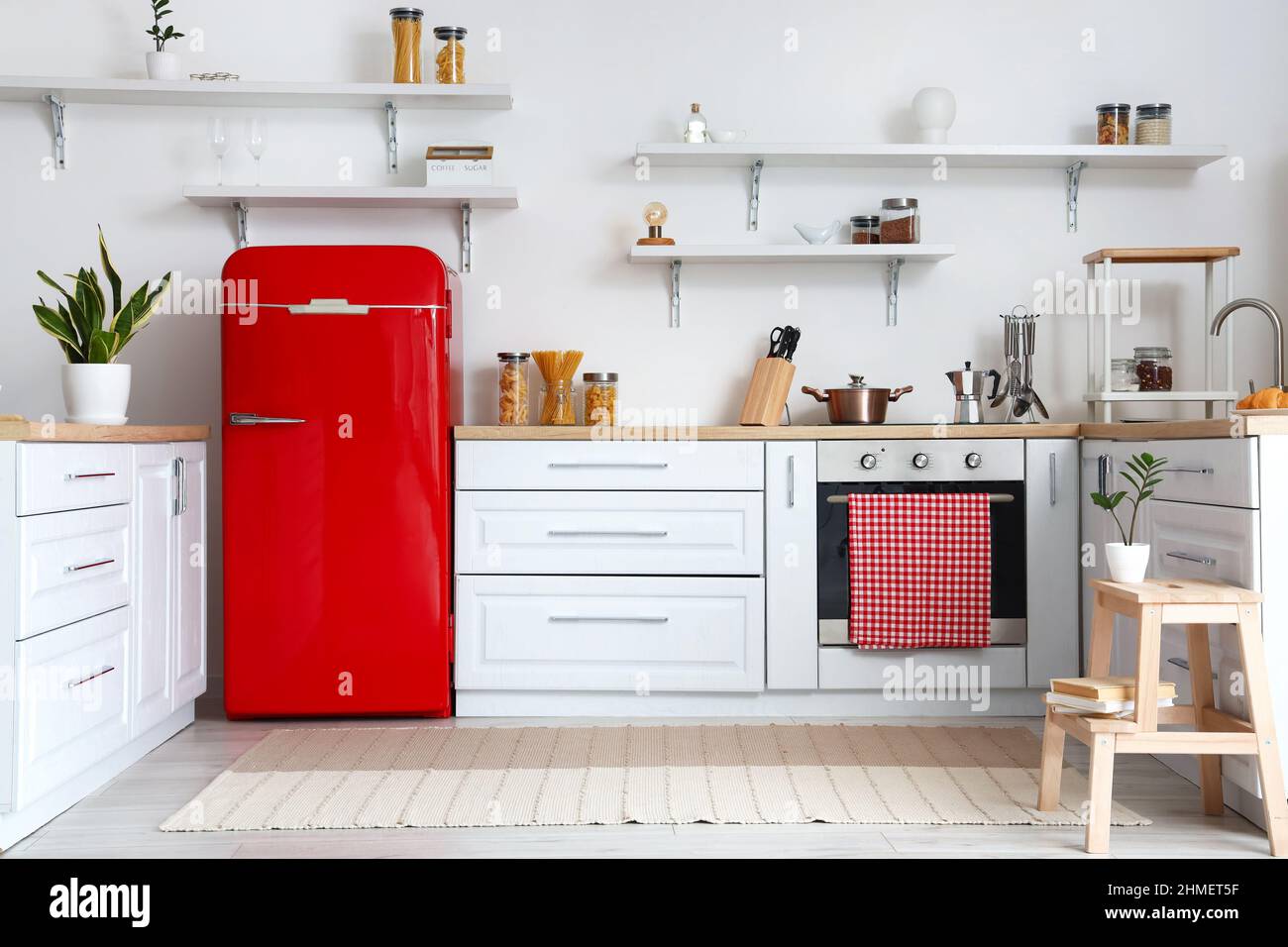 Interior of light kitchen with white counters and red fridge Stock ...