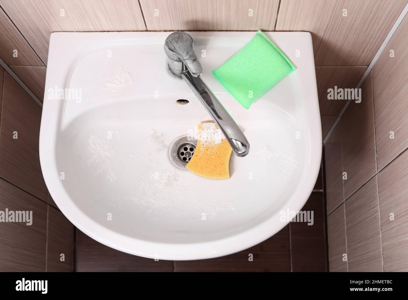 Ceramic sink with cleaning sponge and wipe in bathroom Stock Photo - Alamy