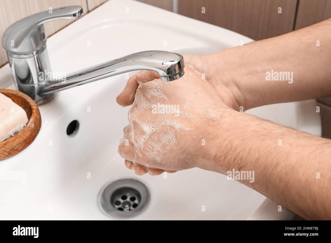 Man washing his hands with liquid soap near sink in bathroom, closeup ...