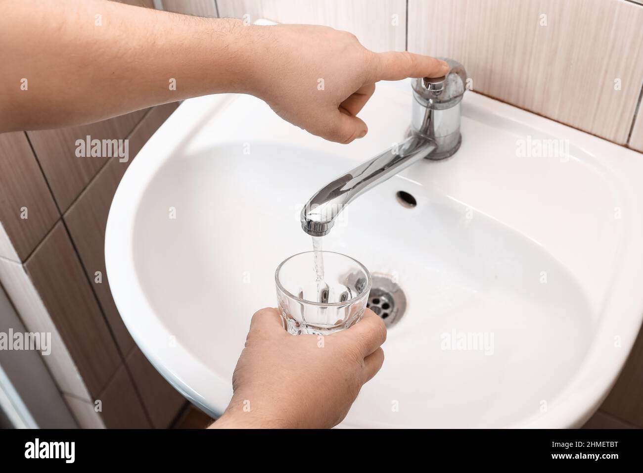 Man turning tap hi-res stock photography and images - Alamy