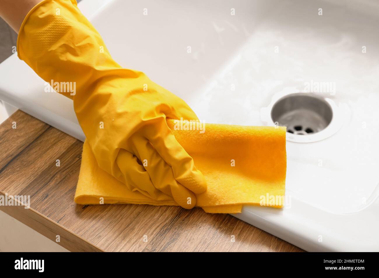 Woman in rubber glove cleaning white sink with wipe, closeup Stock ...