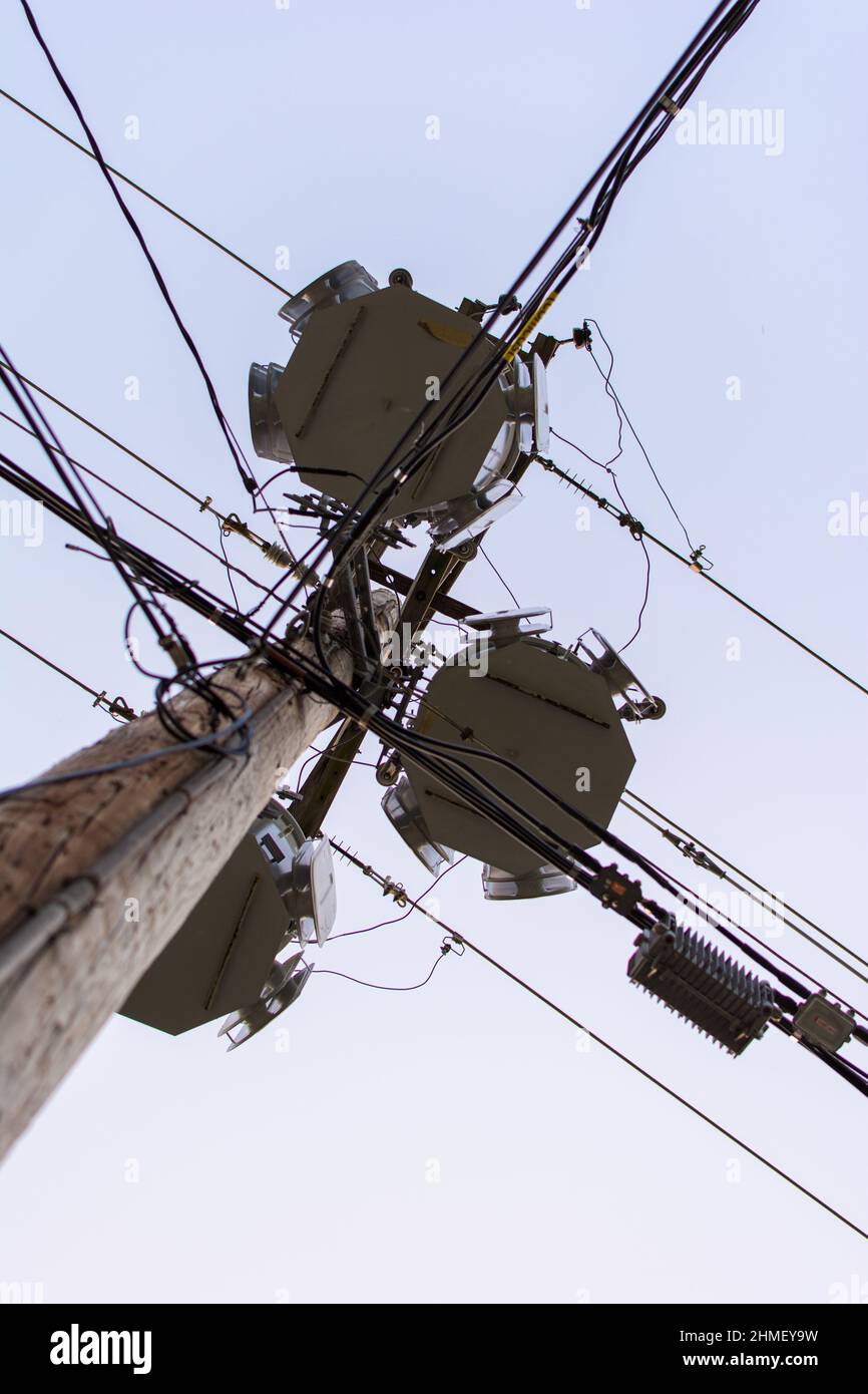 A vertical low angle shot of an Utility pole with cris cossing wires ...