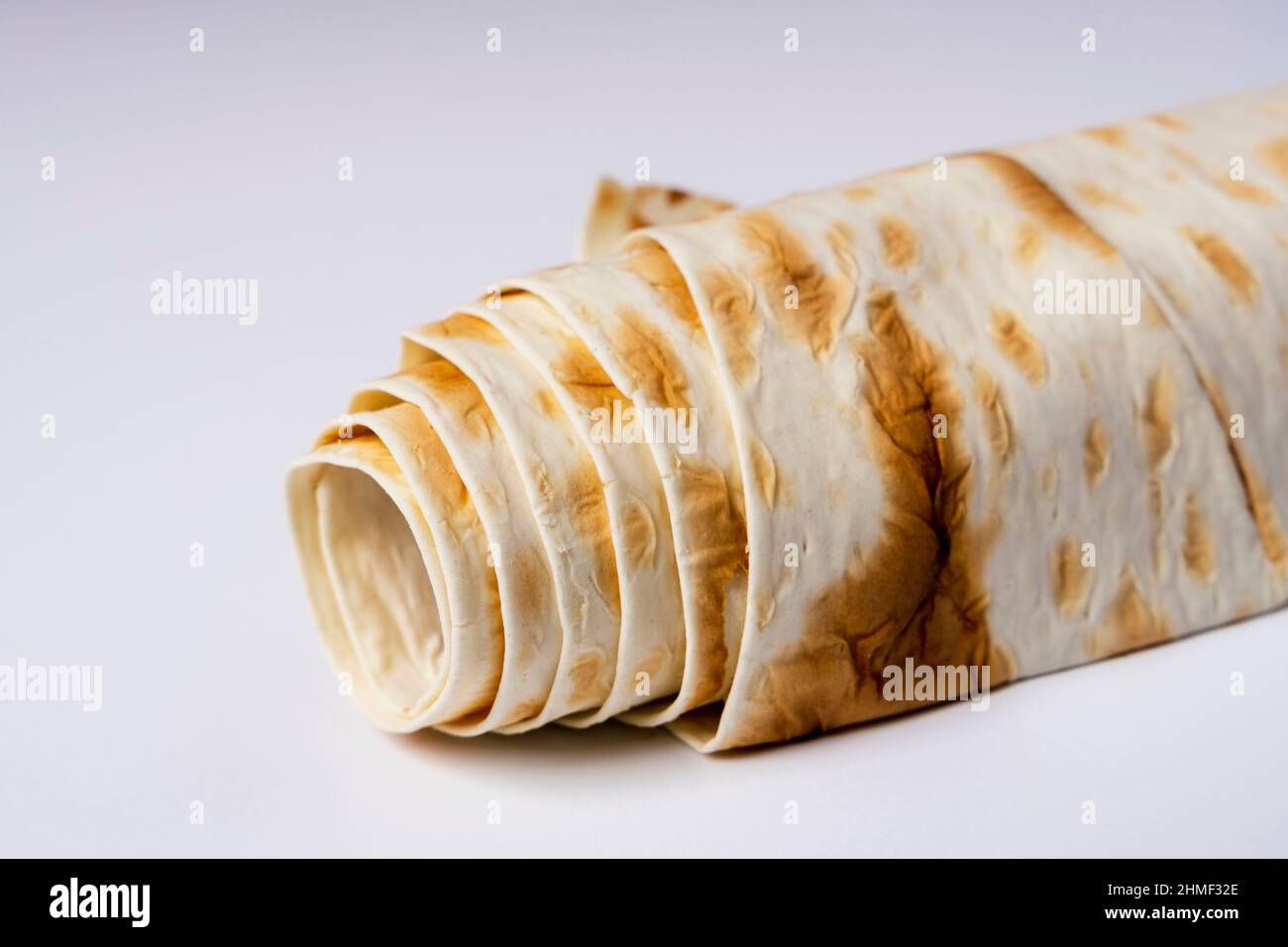 Lavash rolled on a white background, thin traditional oriental bread ...