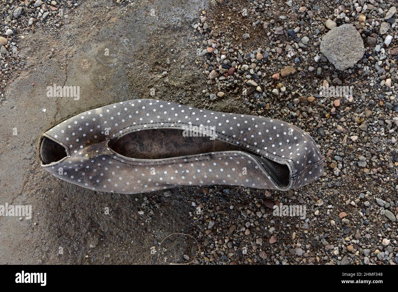 Black and white dotted women's shoe on the floor, dilapidated leather ...