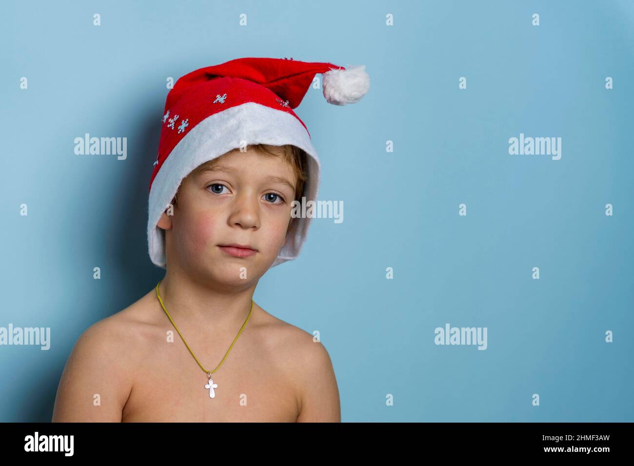 Cute European boy in a St. Nicholas hat on a blue background, Christmas ...