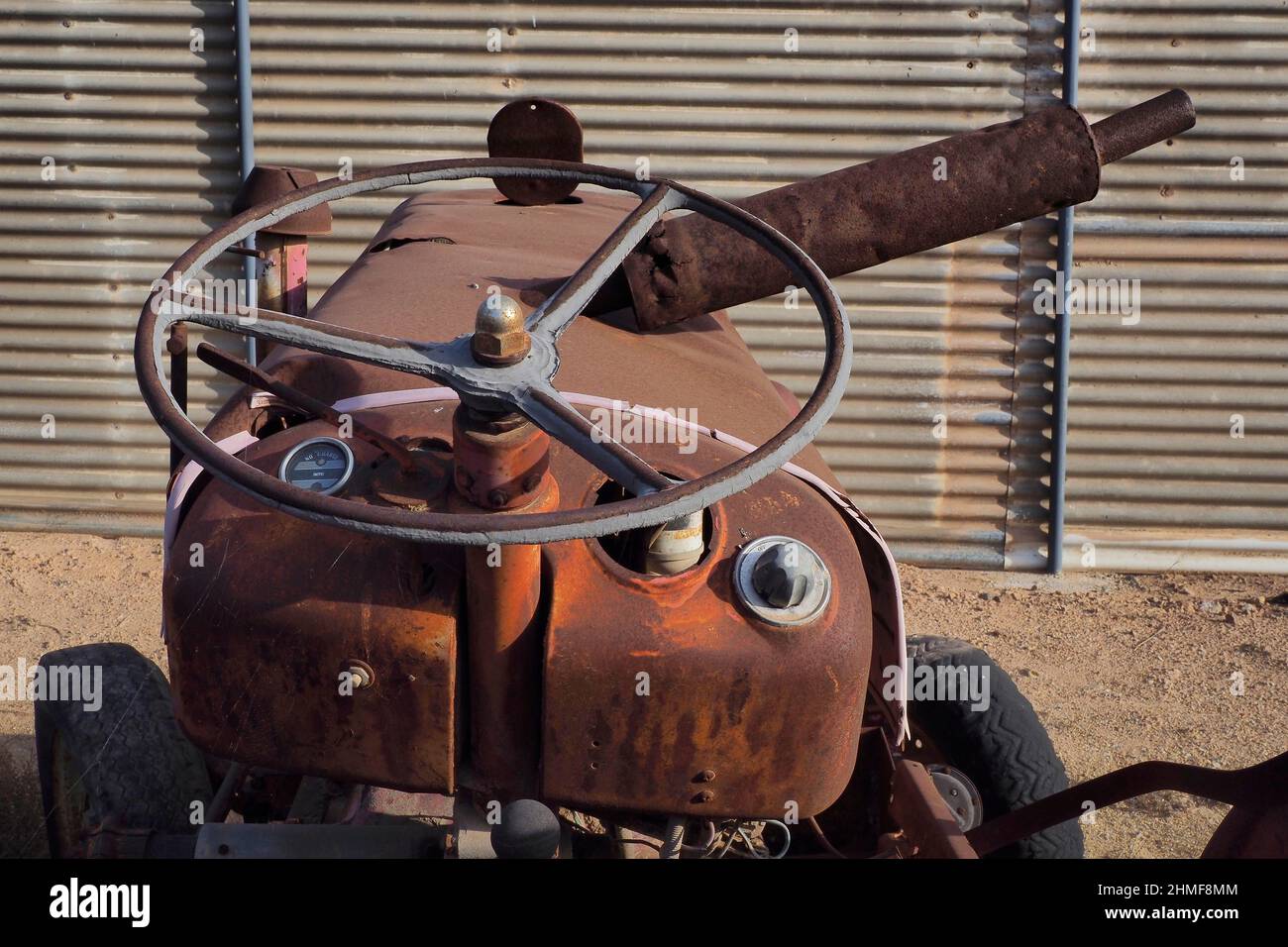 Rusty bonnet of tractor with steering wheel, tractor on scrap yard ...