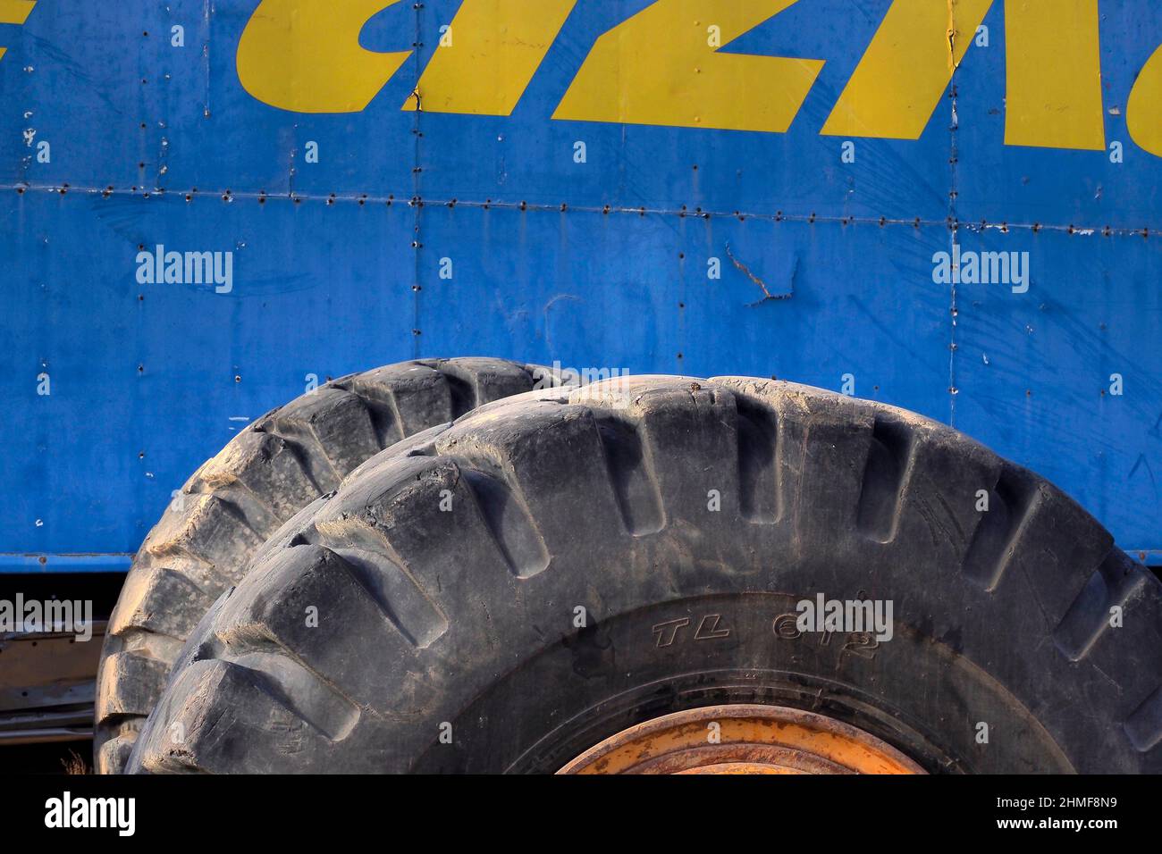Tyres from tractor in front of blue metal from scrap car, scrap yard ...