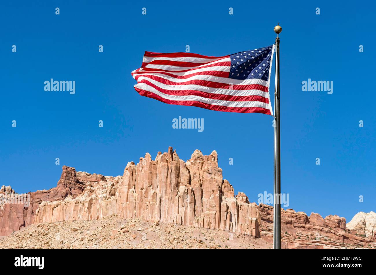 US flag fluttering against a blue sky, behind it the rock formation The ...